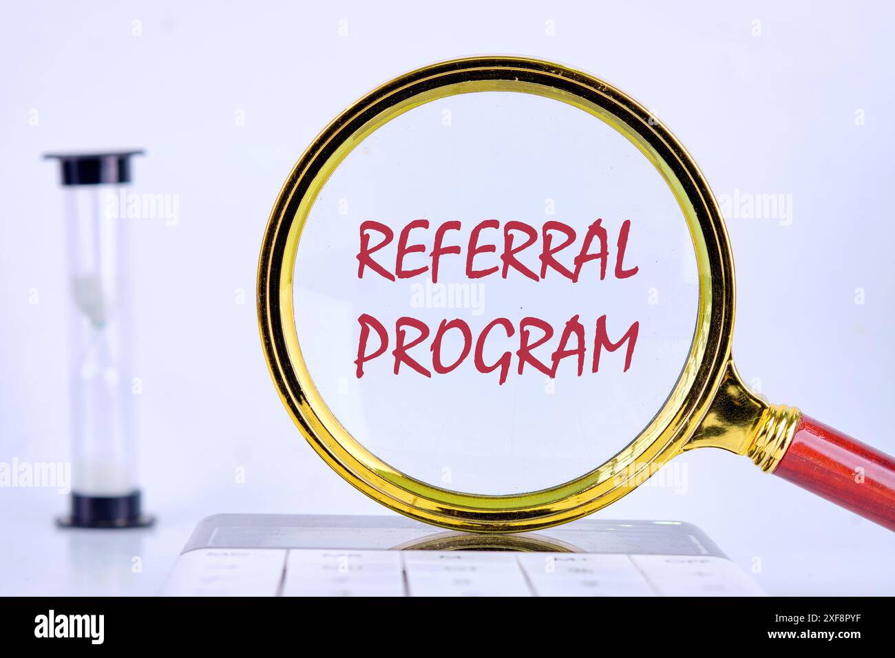 REFERRAL PROGRAM word. text written through the magnifying glass on the ...
