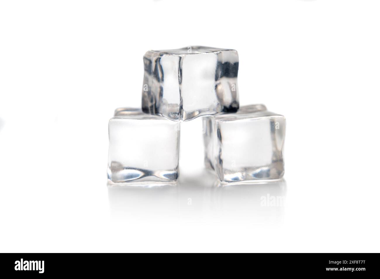 Three ice cubes delicately balance on top of each other, creating a ...