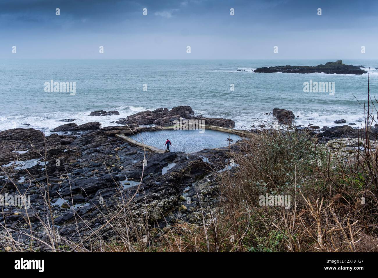The large shallow historic tidal pool on the rocky shore in Mousehole ...