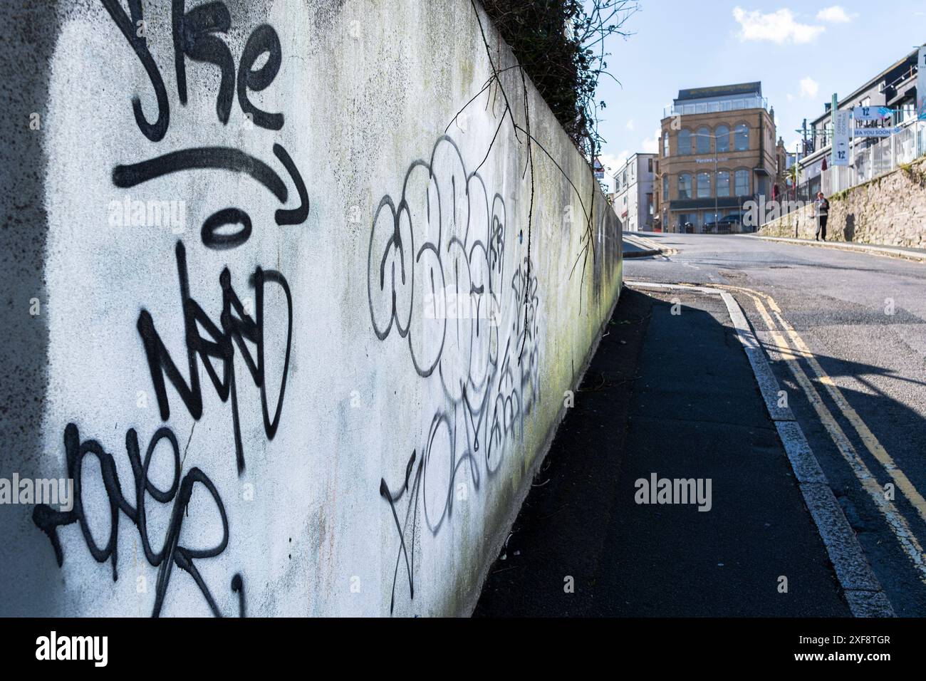 Ugly graffiti defacing a wall along Beach Road Rd in Newquay town ...