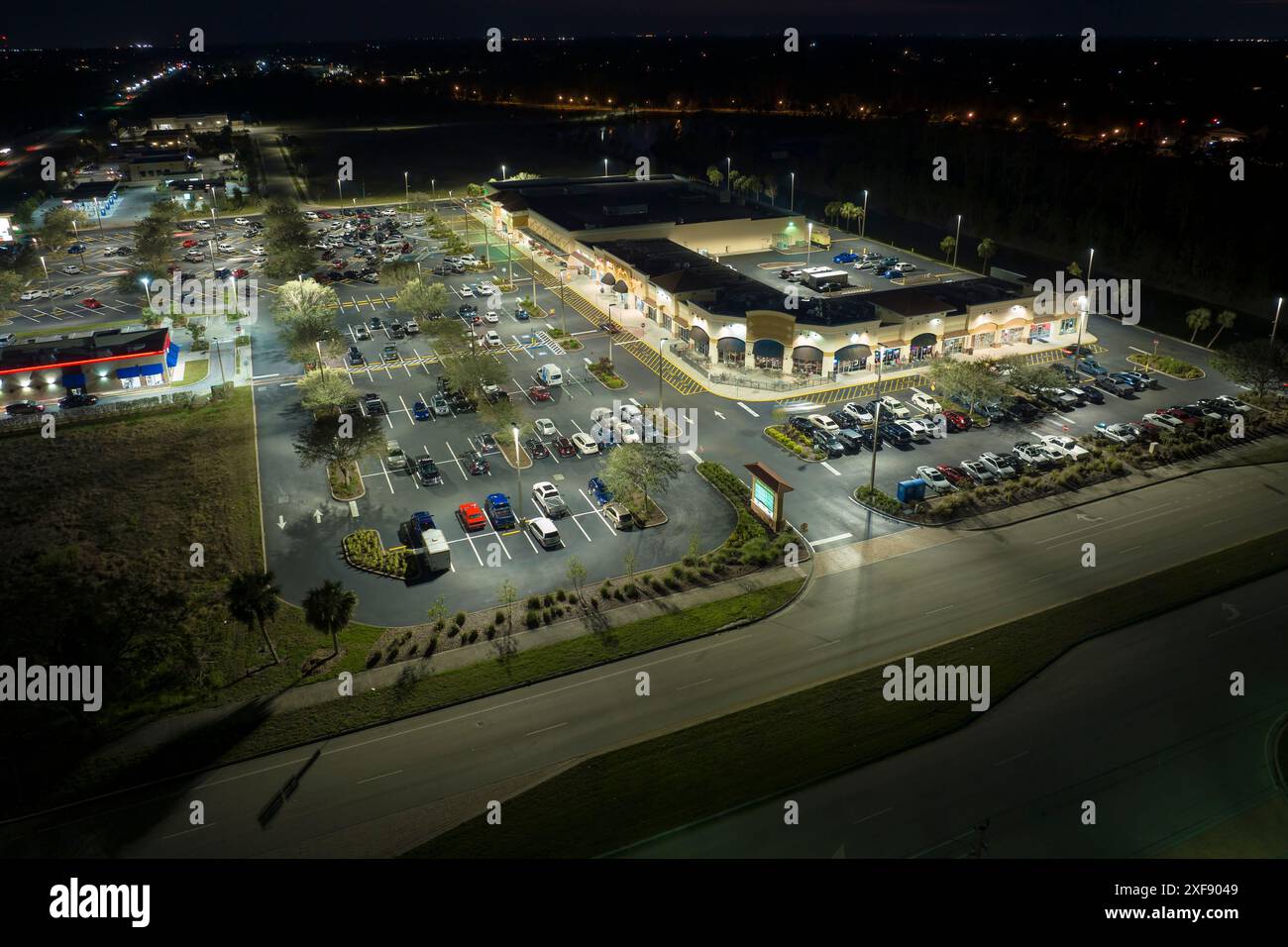 Aerial view of large parking lot at nighttime with many parked cars ...