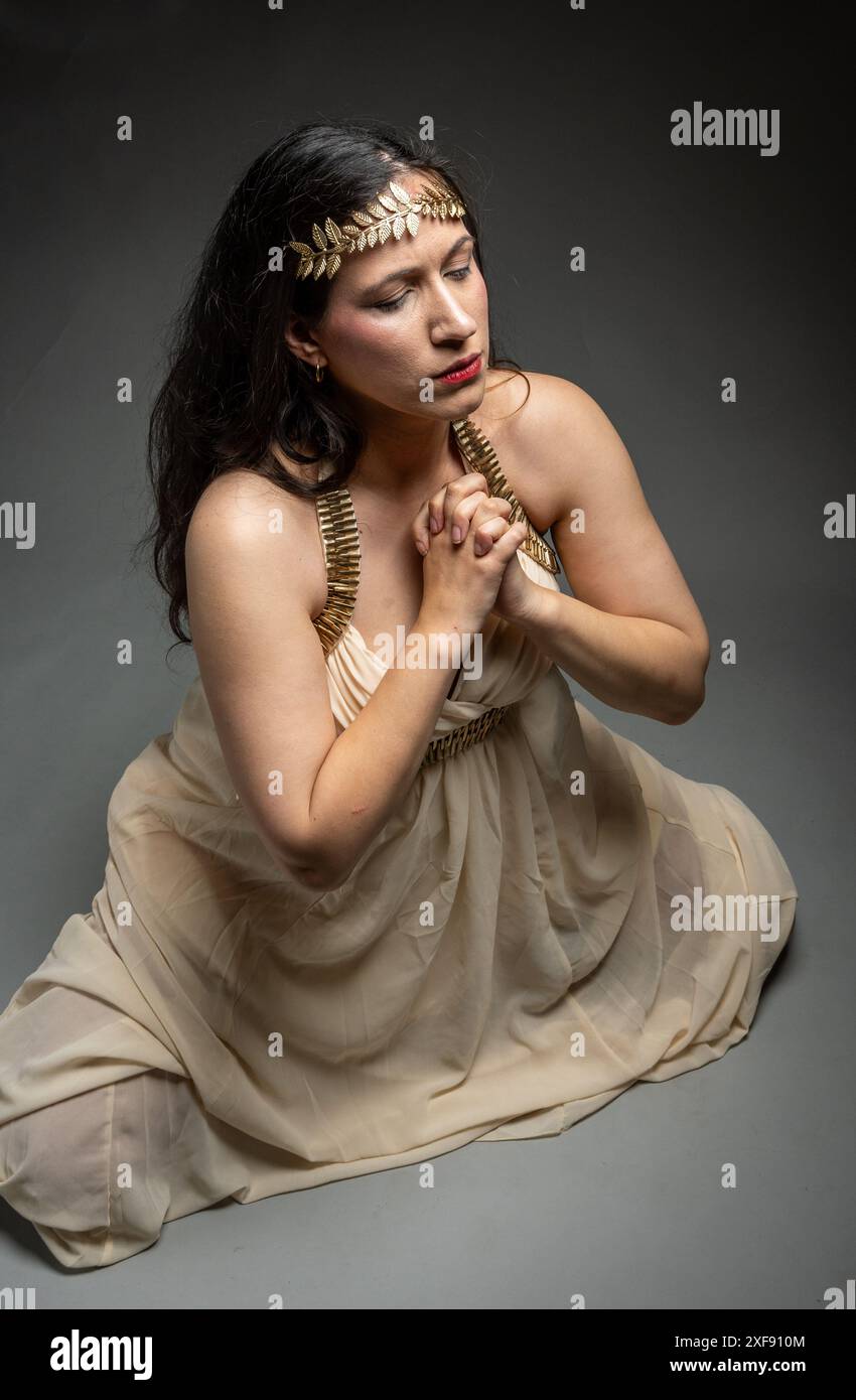 Roman or Greek style slave girl on floor praying with hands on chest Stock Photo - Alamy