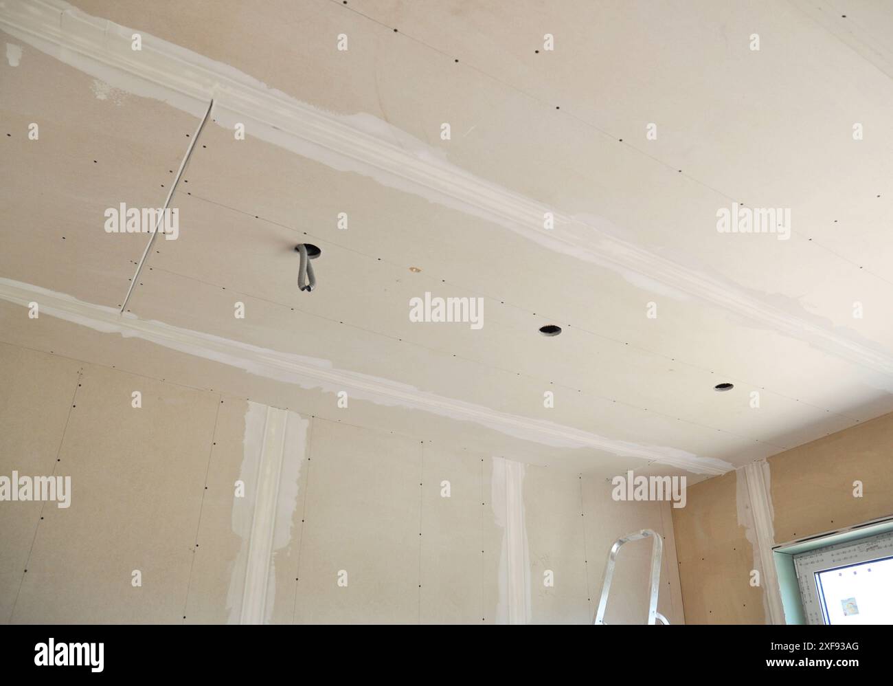Close up on recessed lighting holes on the ceiling in the plasterboard ...