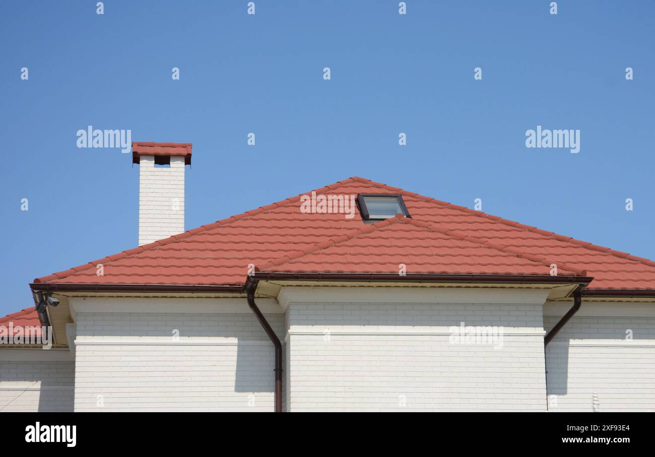 House attic rooftop with red clay tiles, skylight window, chimney ...
