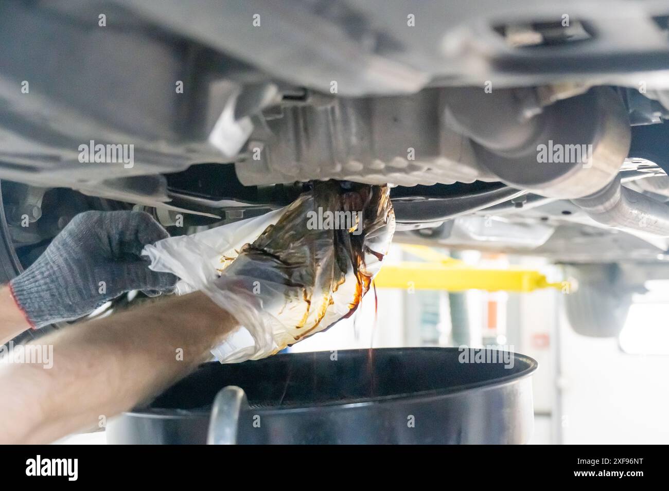A mechanic drains a car's used engine oil Stock Photo - Alamy