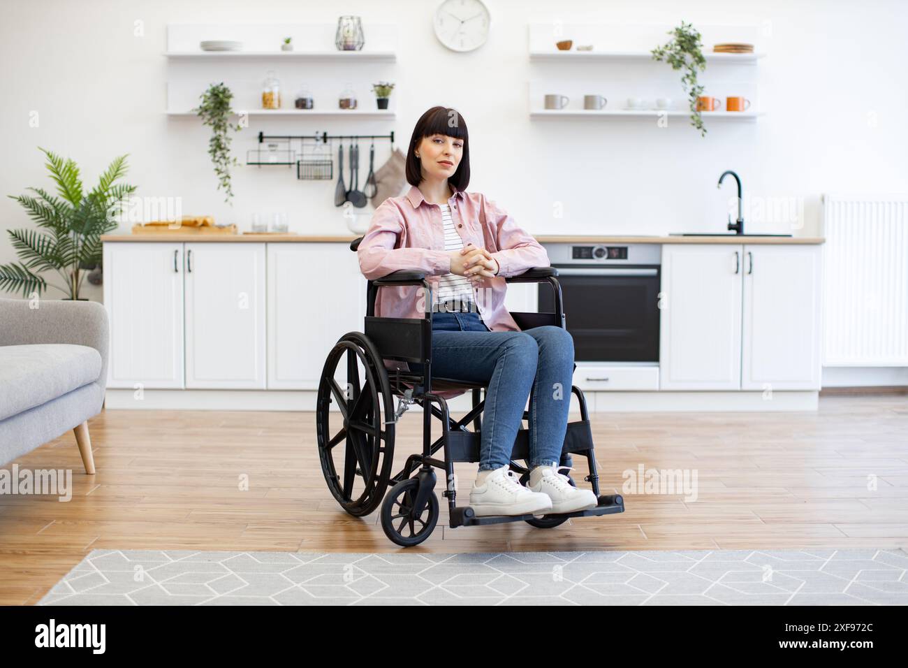 Woman in wheelchair sitting in modern kitchen environment Stock Photo ...