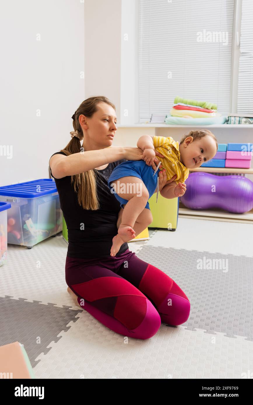 Infant neurological examination with arm traction in a physical therapy ...