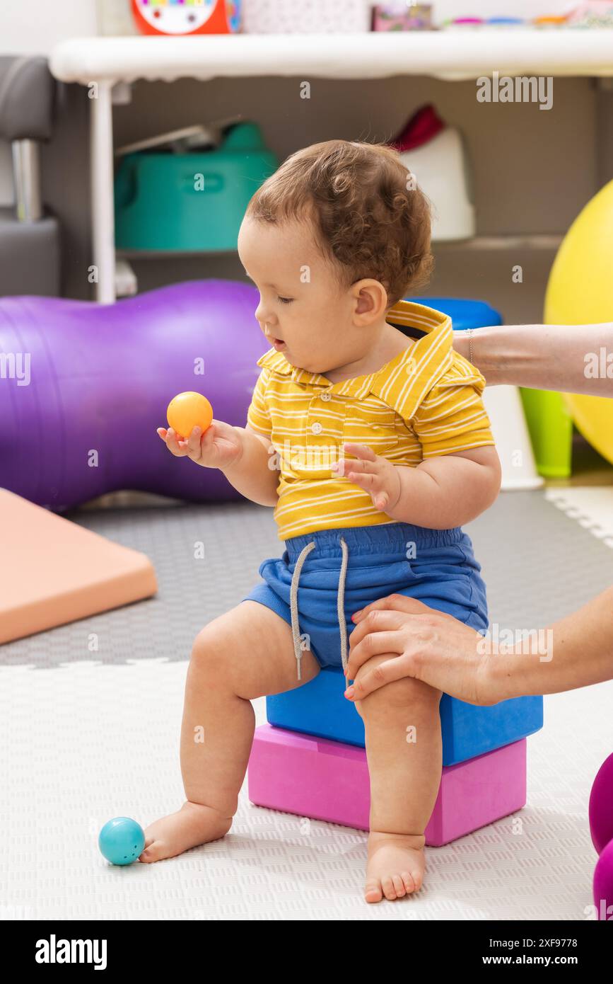 Therapist assists a young injured child in physical therapy for birth ...