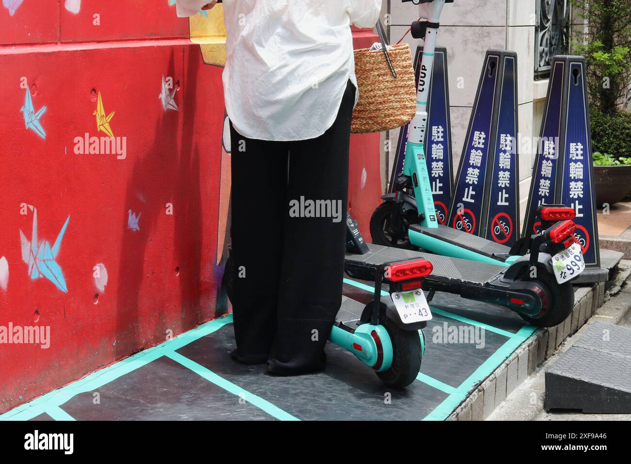 TOKYO, JAPAN - June 16, 2024: Person renting a Luup rental e-scooter ...