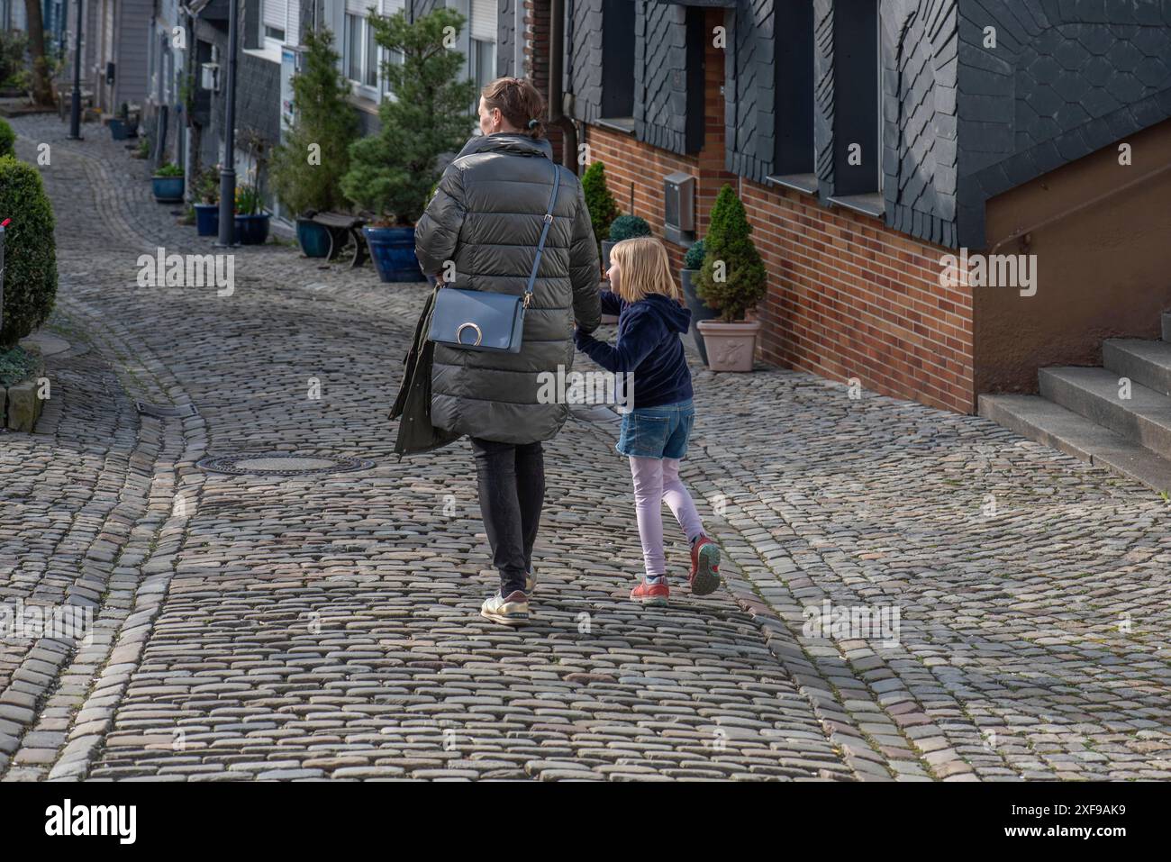 Mother and daughter walking through the old town centre of Siegen ...