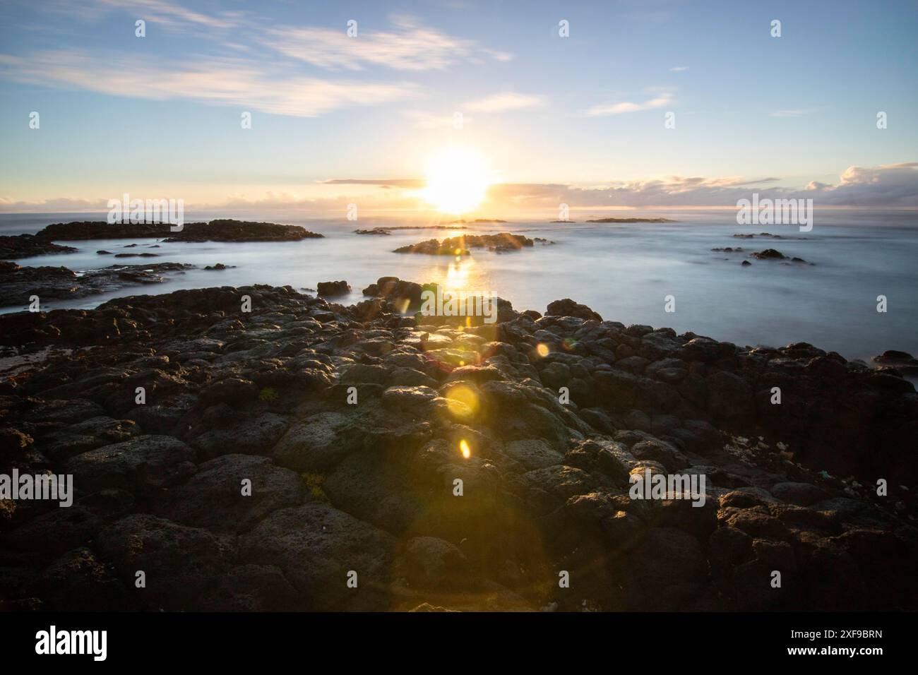 Sunrise over the sea, long exposure. sandy beach beach with lava stones ...