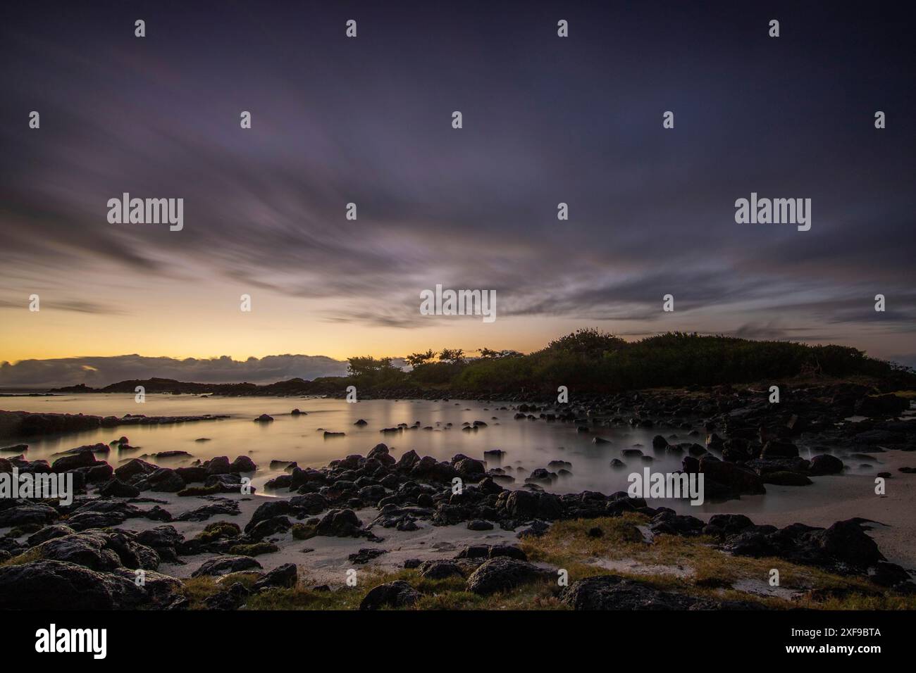 Sunrise over the sea, long exposure. sandy beach beach with lava stones ...