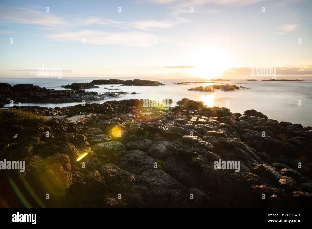 Sunrise over the sea, long exposure. sandy beach beach with lava stones ...