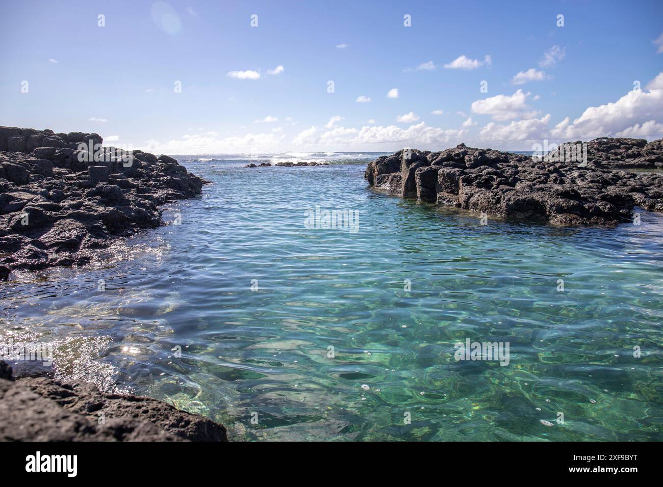 Beautiful lava beach during the day. Lava rocks alternate with crystal ...