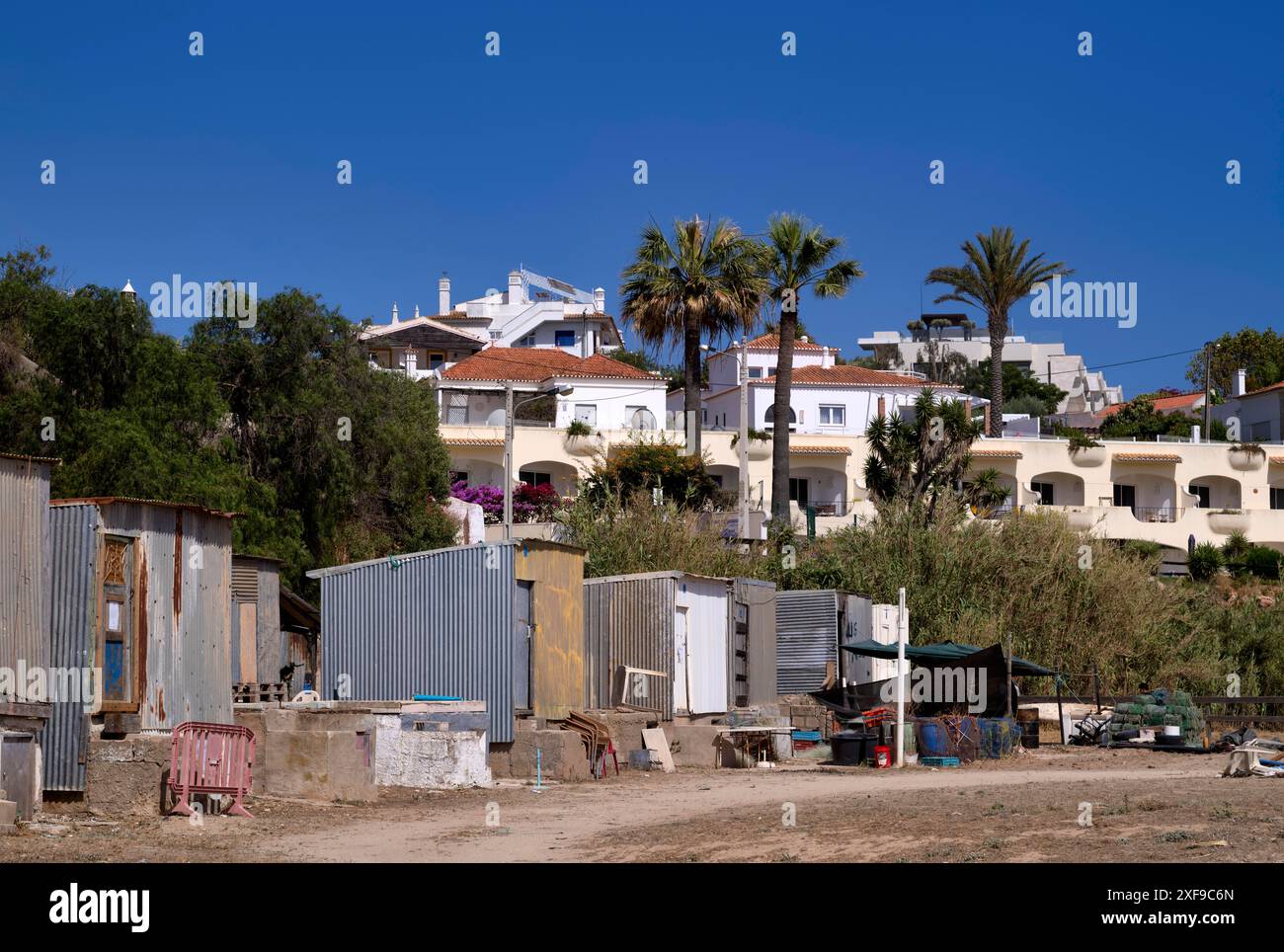 Corrugated iron huts, dwellings of labourers, behind them villas ...