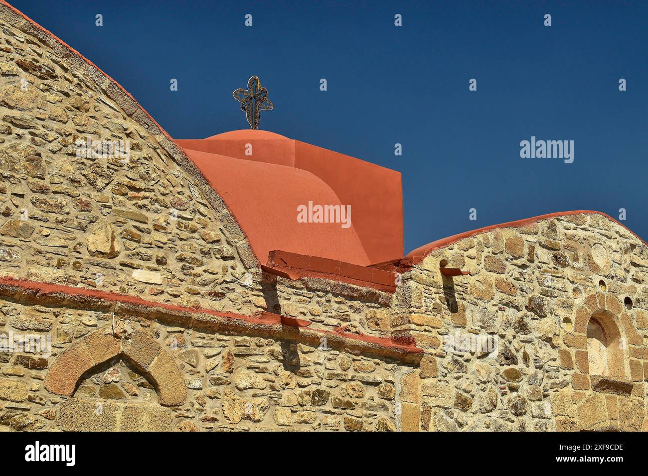 Historic church with stone facade and red roof under a clear blue sky ...