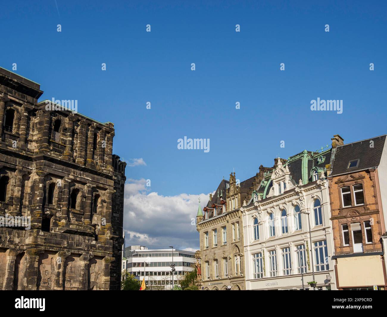 Old building next to modern structures, sky with scattered clouds ...