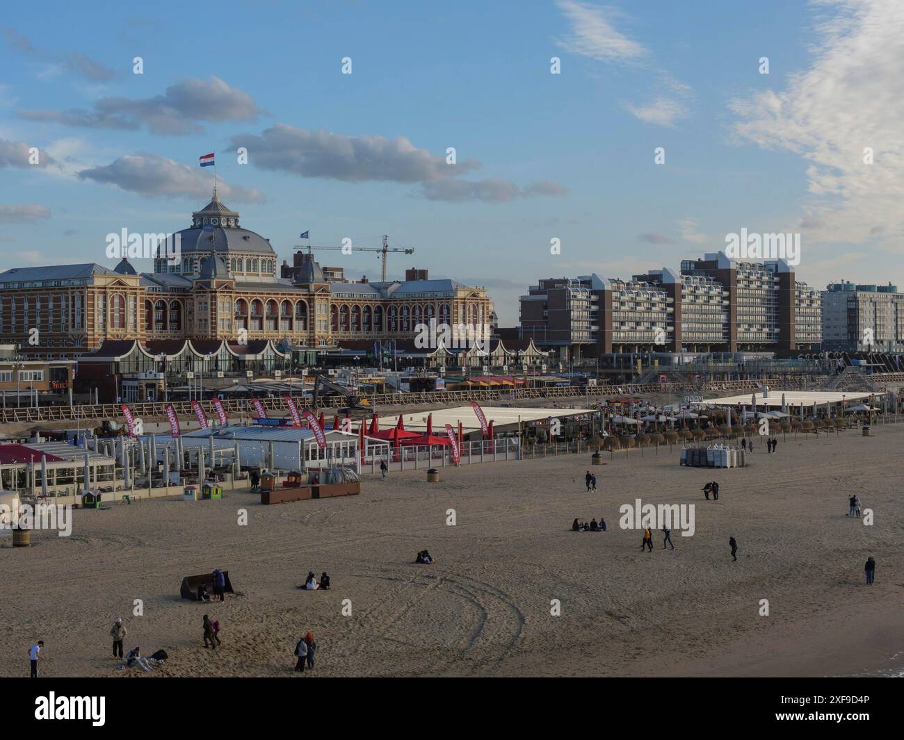 Beach scene with buildings and people in the background, cloudy sky ...