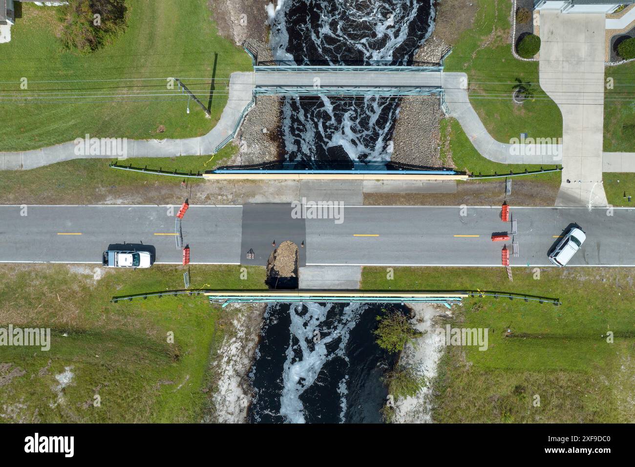 Police car blocking road access at destroyed bridge after hurricane ...