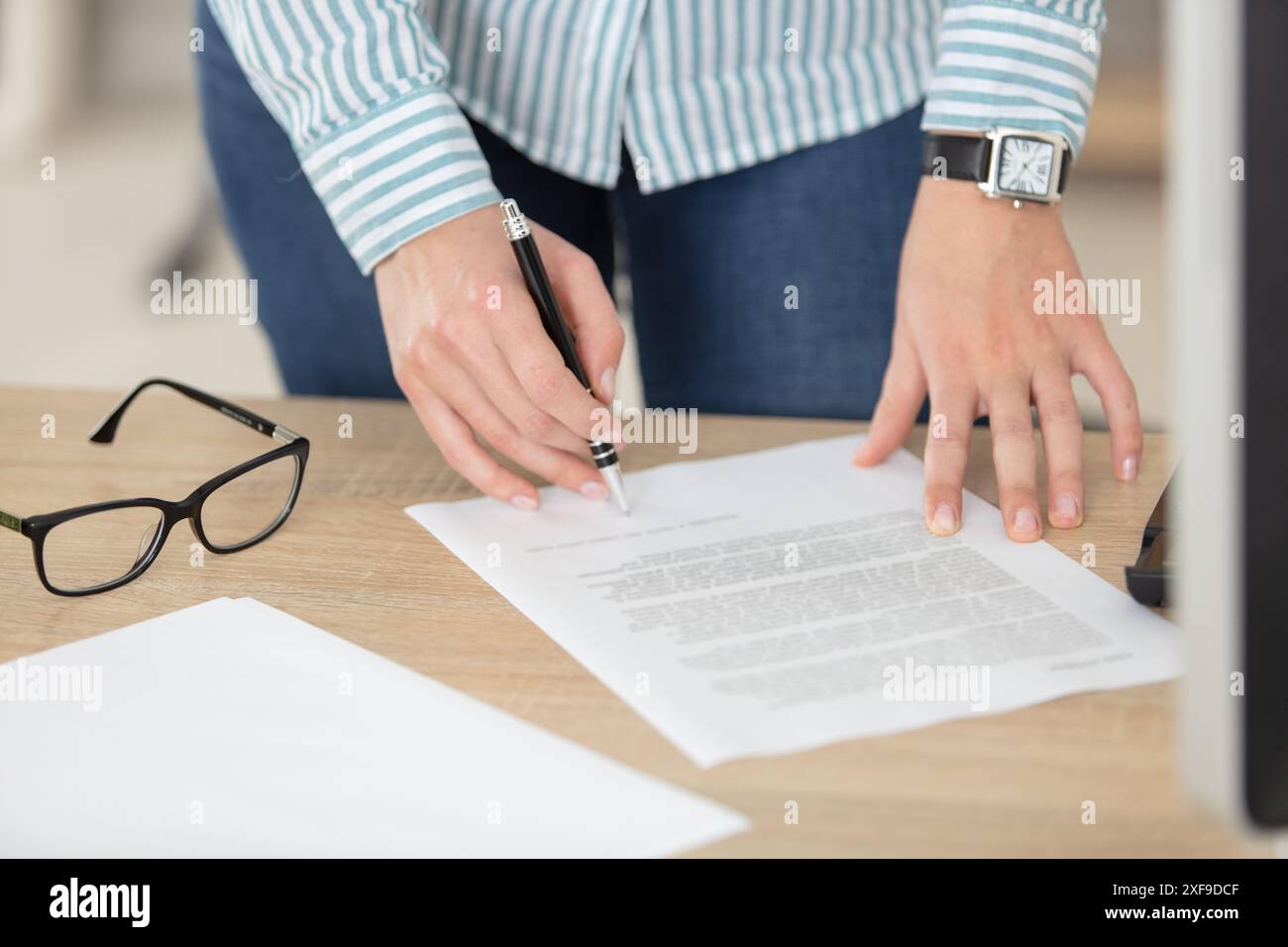 Woman signing document in office hi-res stock photography and images ...