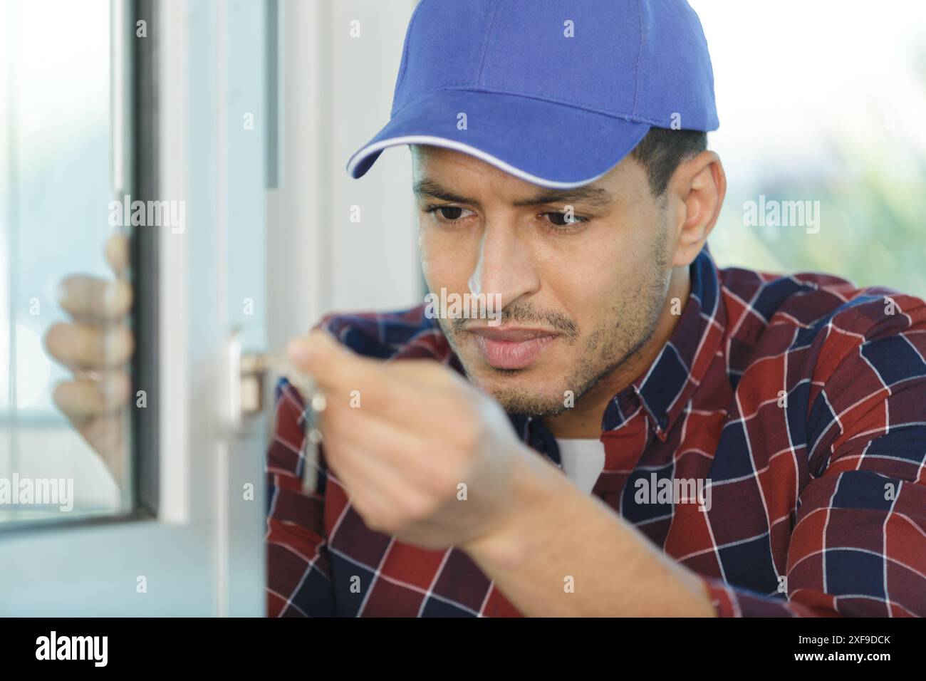 a young male worker fixing a window frame Stock Photo - Alamy