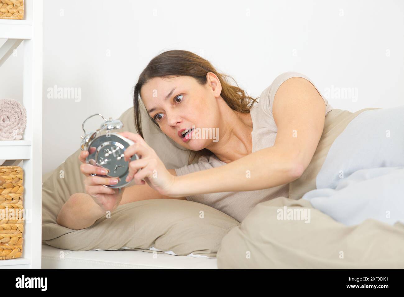 shocked woman waking up with alarm Stock Photo - Alamy
