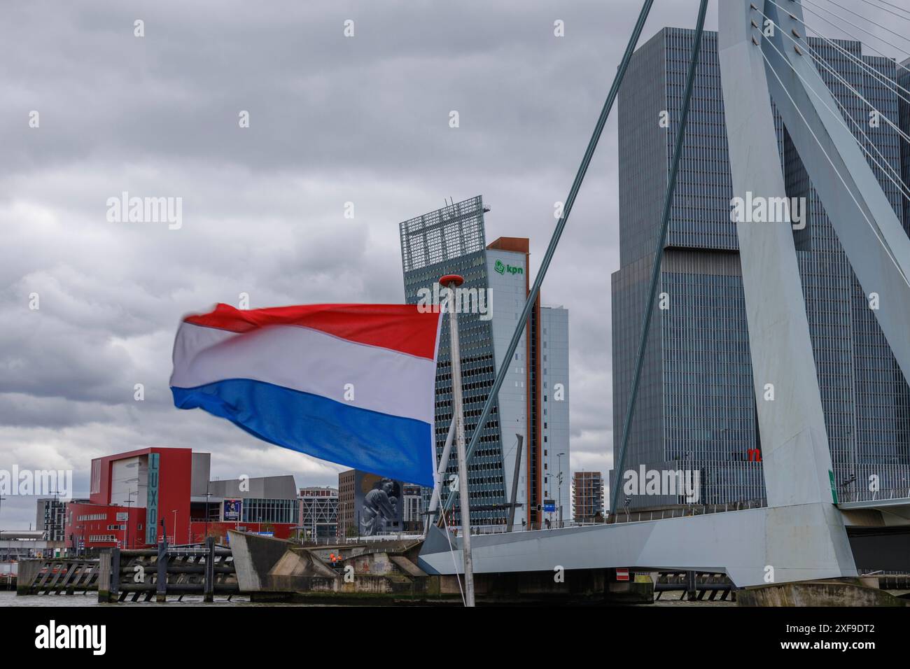 Dutch flag waving in front of a bridge and modern buildings under a ...