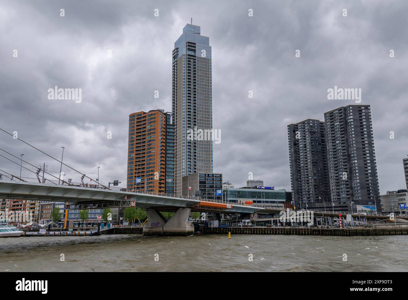 Skyscrapers and a bridge in a modern cityscape under a cloudy sky ...