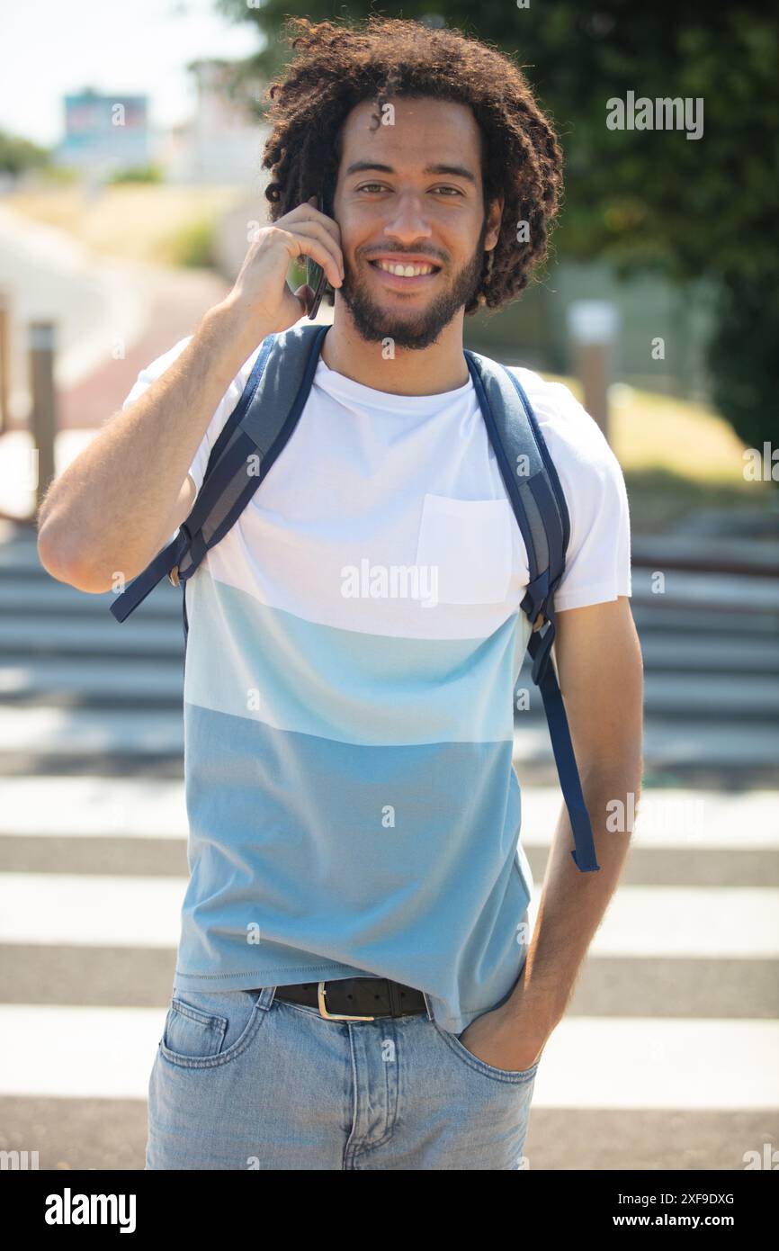 man walking by a pedestrian crossing with the phone Stock Photo - Alamy