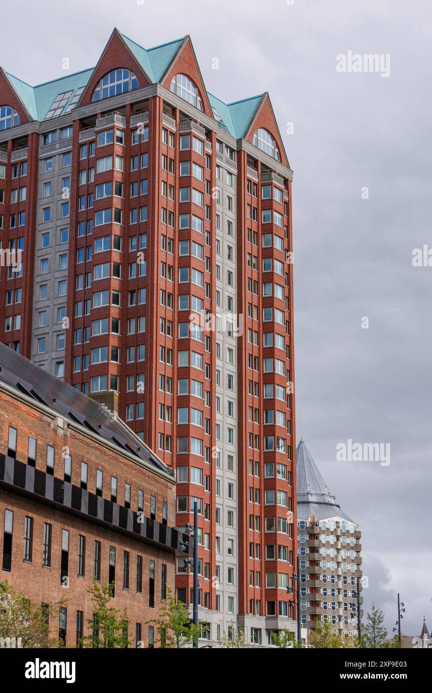 Tall modern residential building with red and grey facades and glass ...