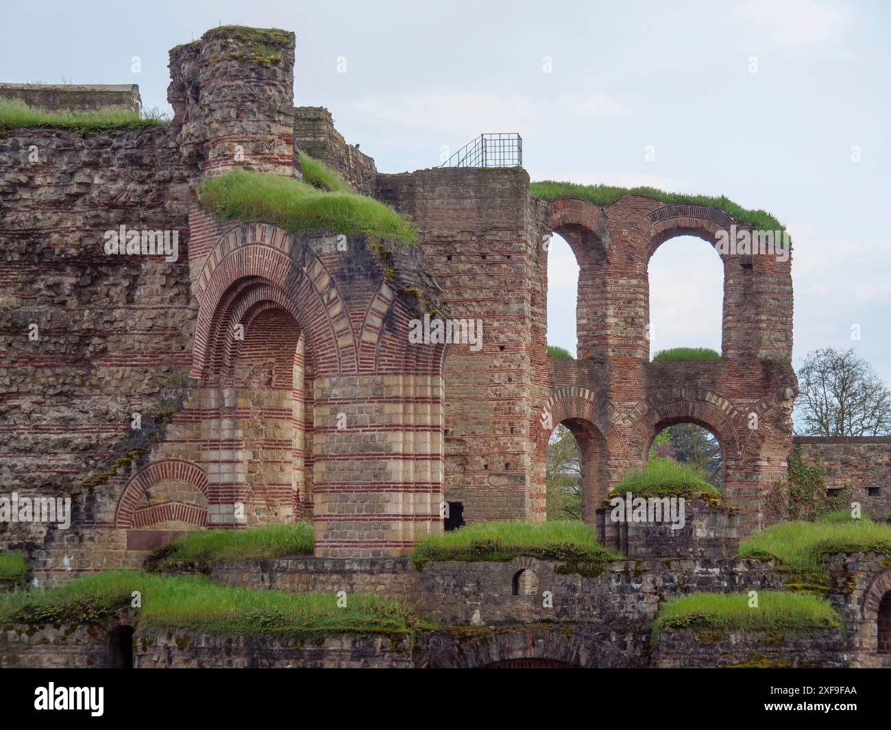 Roman ruins with impressive stone arches and wall-covered grass that ...