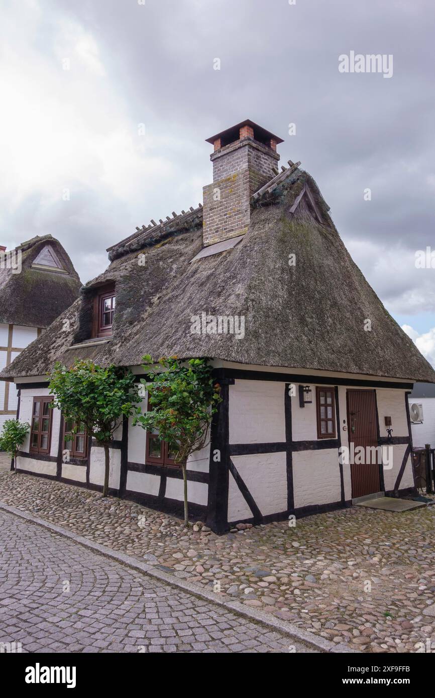 Small half-timbered house with thatched roof, chimney, cobbled street ...