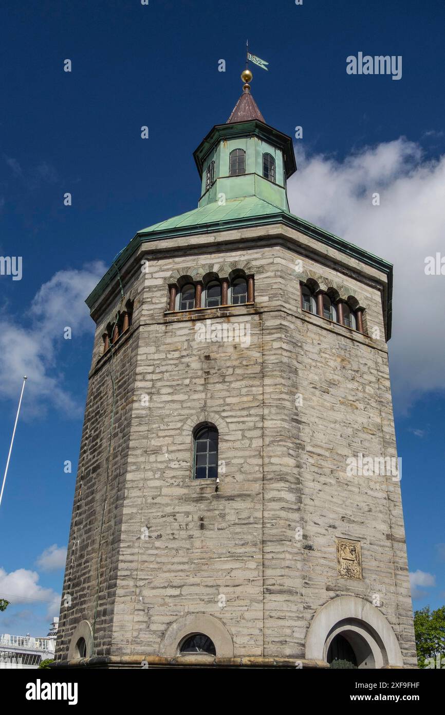 Historic stone tower with green spire and arched windows under a blue ...
