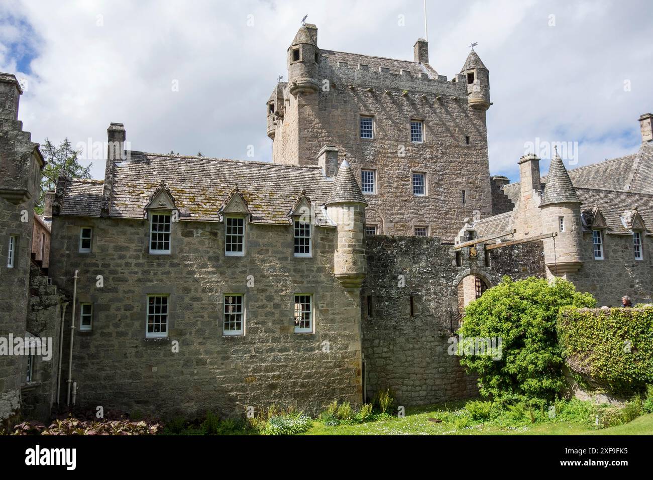Historic castle with stone walls and towers on a green lawn under a ...