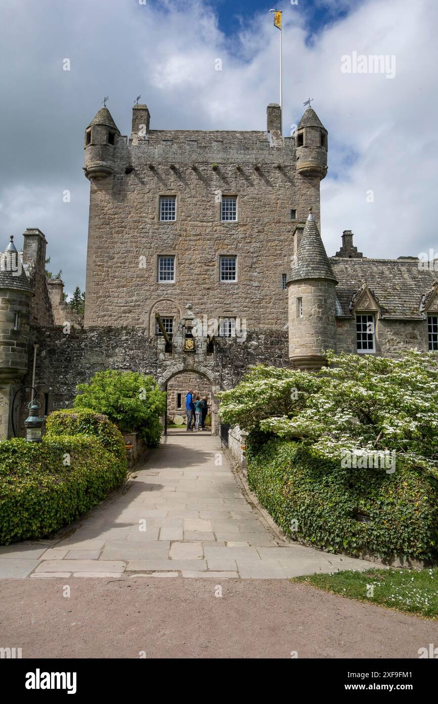 A medieval castle with stone walls and towers, surrounded by manicured ...