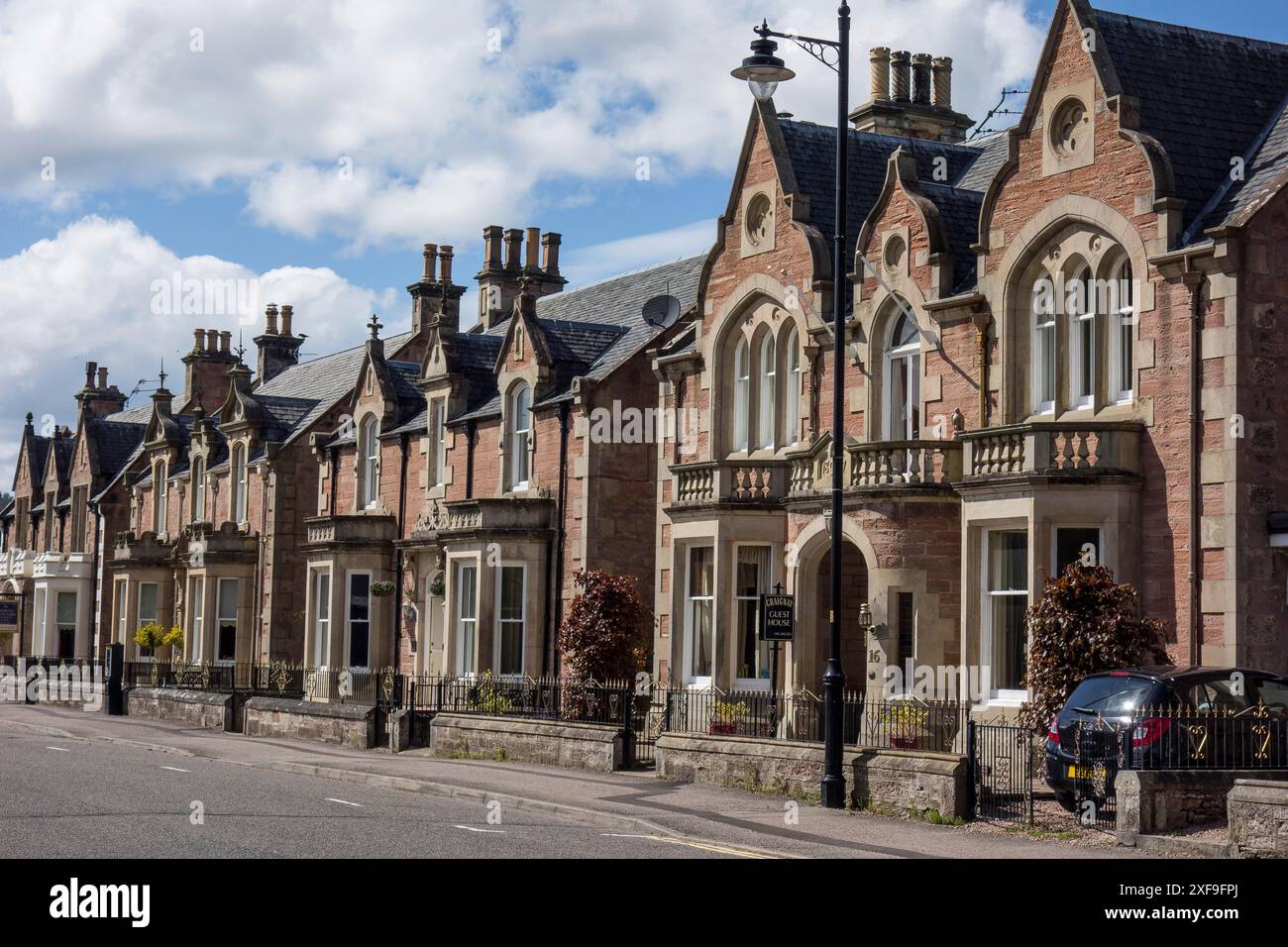Street with historic Victorian brick houses under a cloudy sky ...