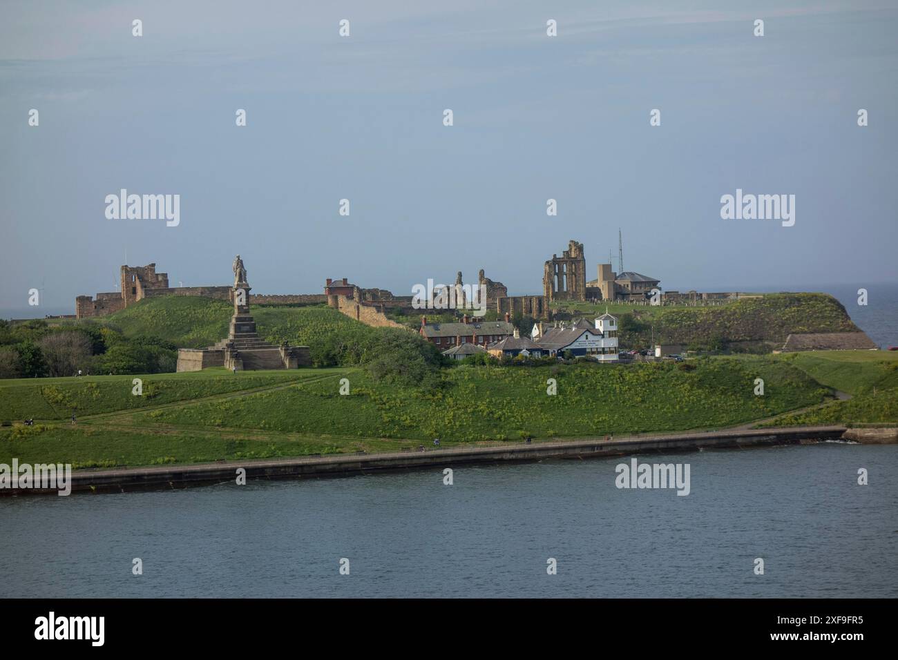 Historic ruins and monuments on green hills by the water under a clear ...