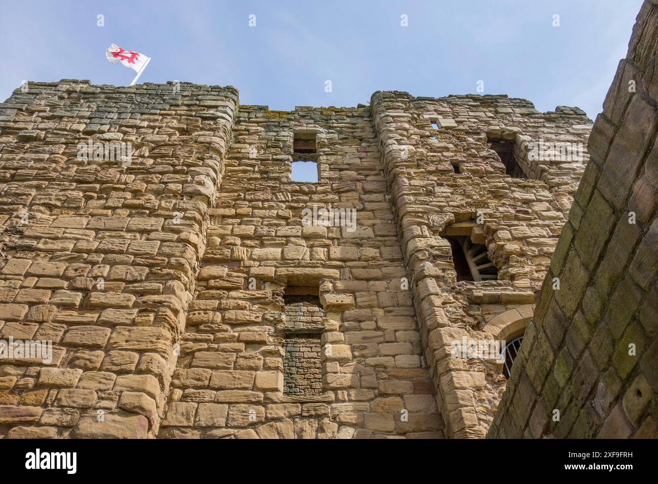 Historic fortress with stone walls and a flag fluttering above it ...
