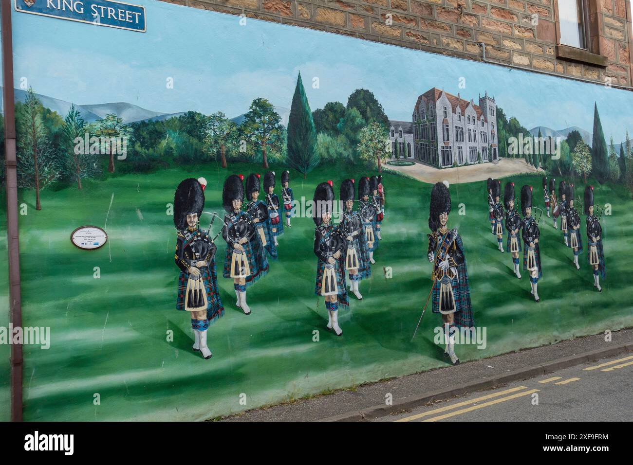 Mural showing bagpipers in traditional Scottish dress in front of a ...
