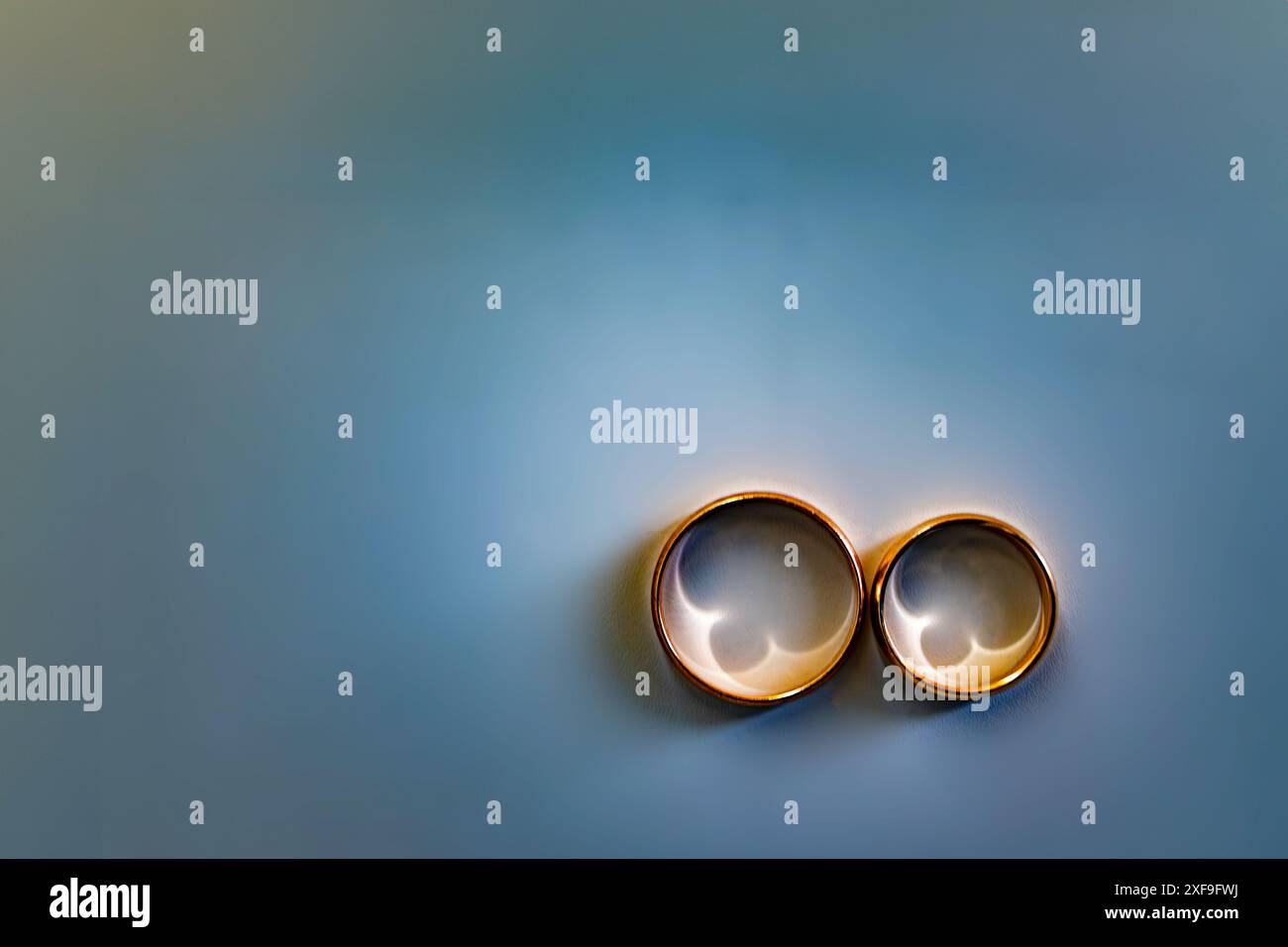 Engagement rings with spectacular sunlight shadows on blue background ...