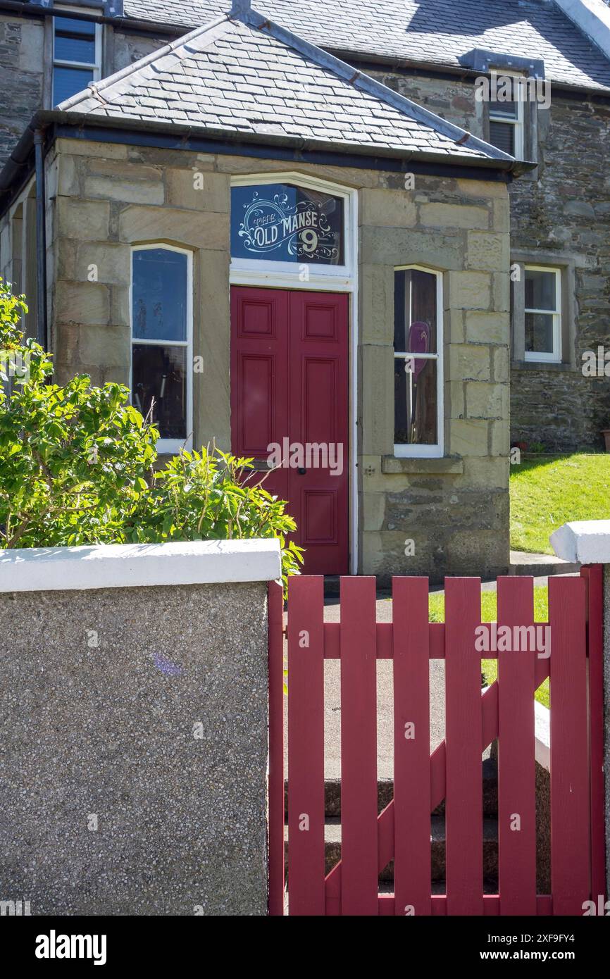 Charming old house with striking red door and windows, surrounded by a ...