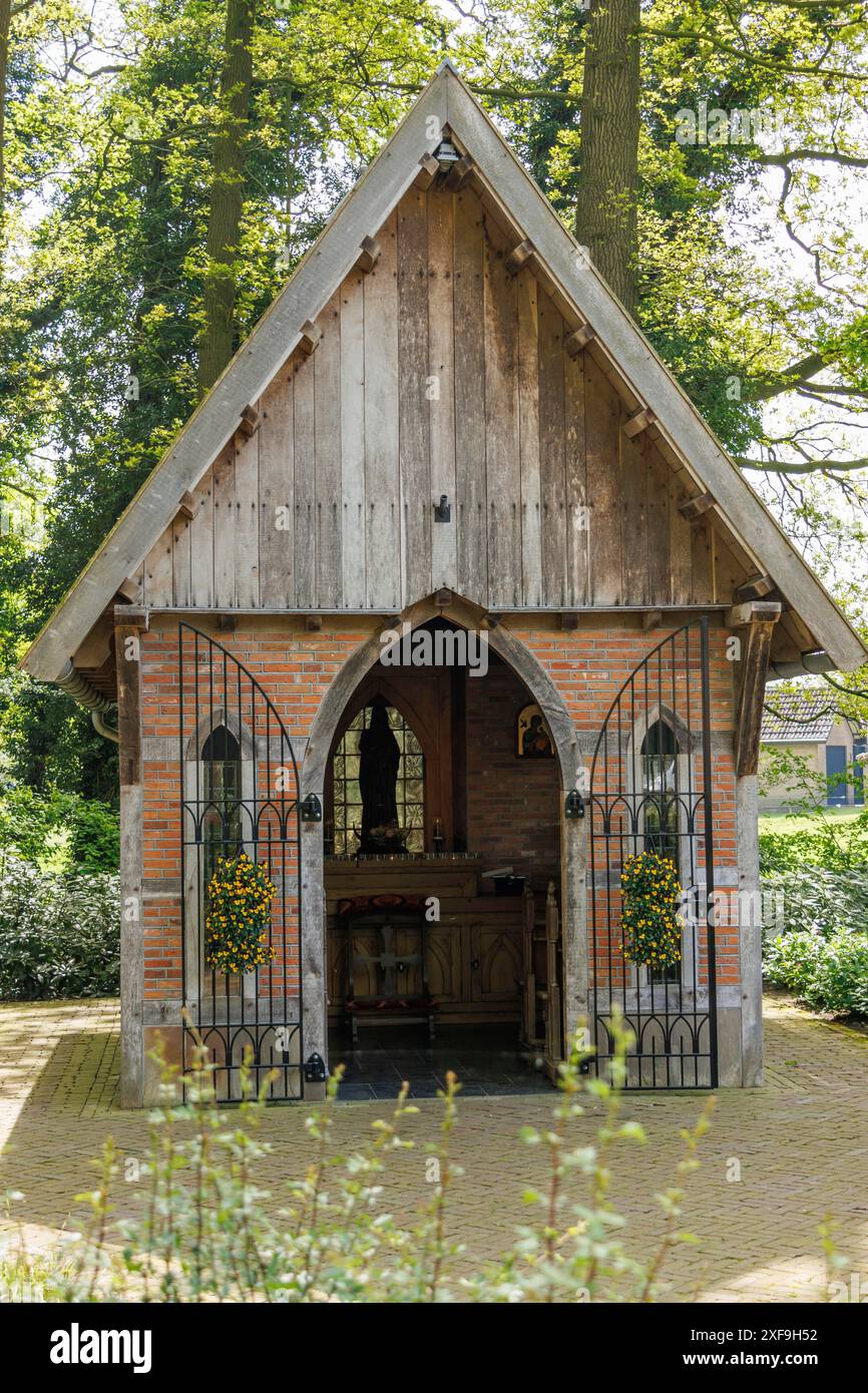 Rustic brick chapel with gothic arches, surrounded by green trees ...