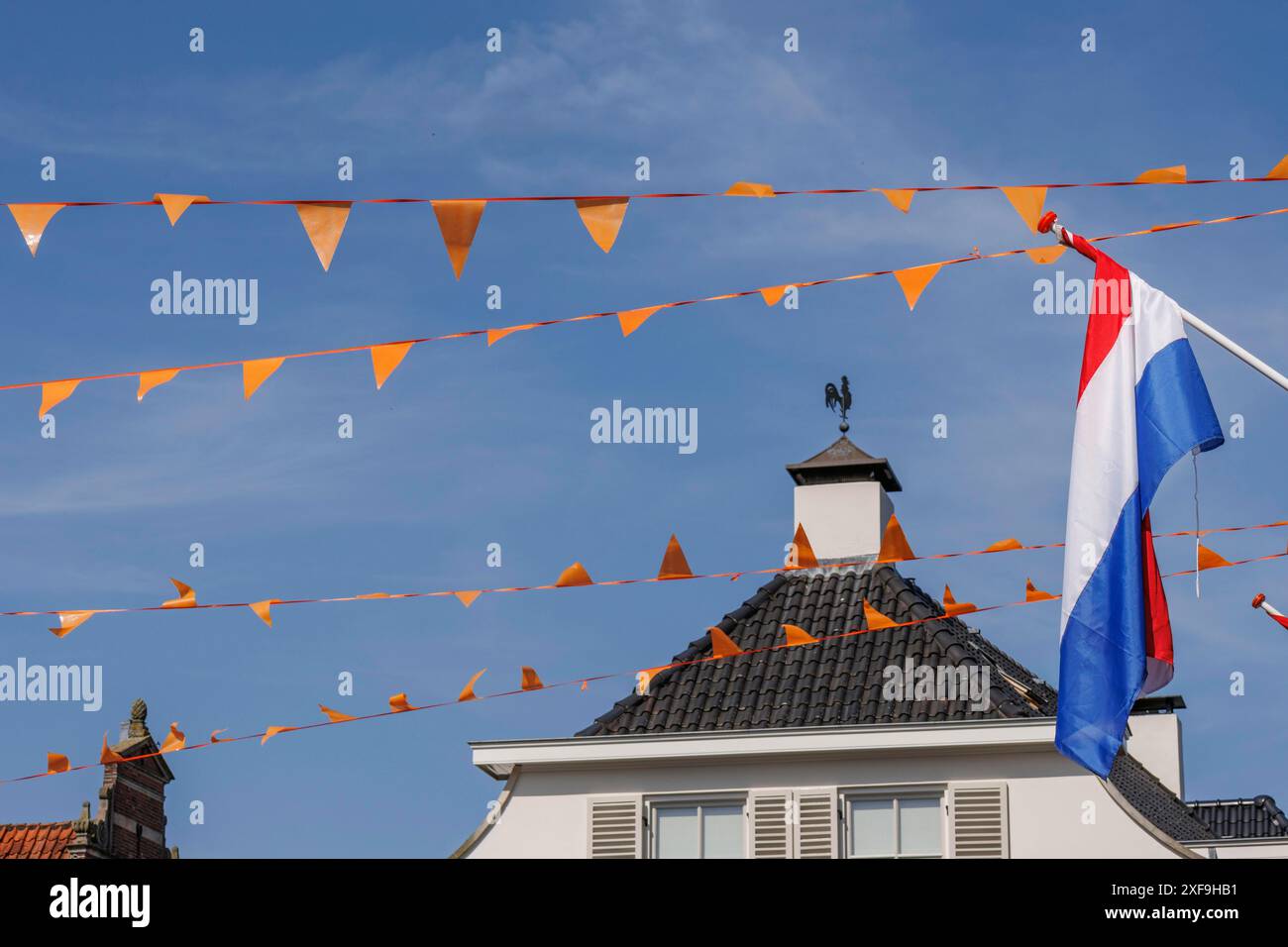 Building with Dutch flag and orange flags in front of a blue sky ...