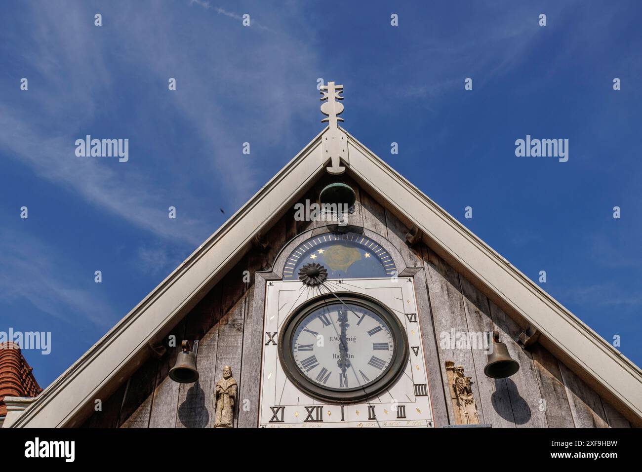 Building gable with large clock and bells in front of a cloudless blue sky, ootmarsum ...