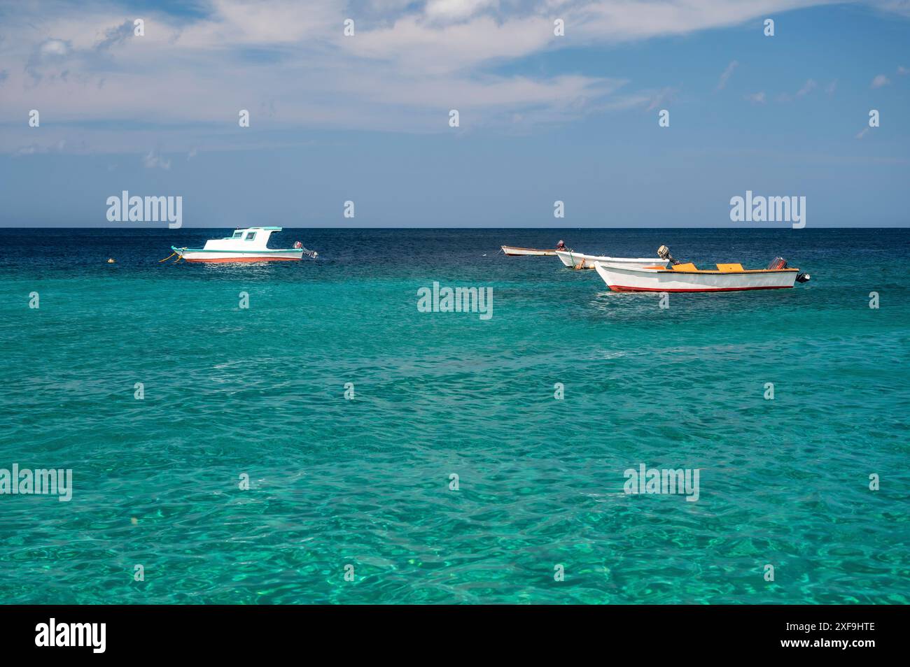 small boats, anchored in the sea, just off the coast of Playa Grandi ...