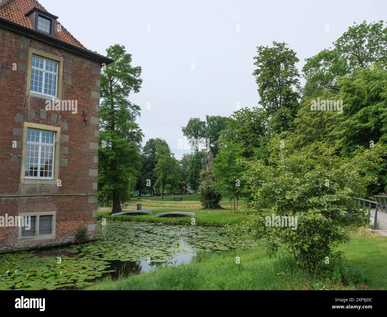 View of the castle and the surrounding garden with moat, green trees ...