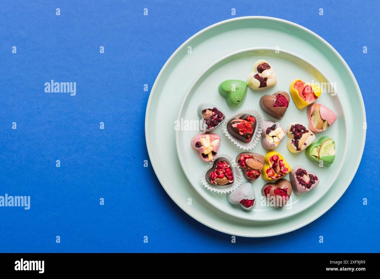 Plate with different chocolate on colored background. Assortment of ...