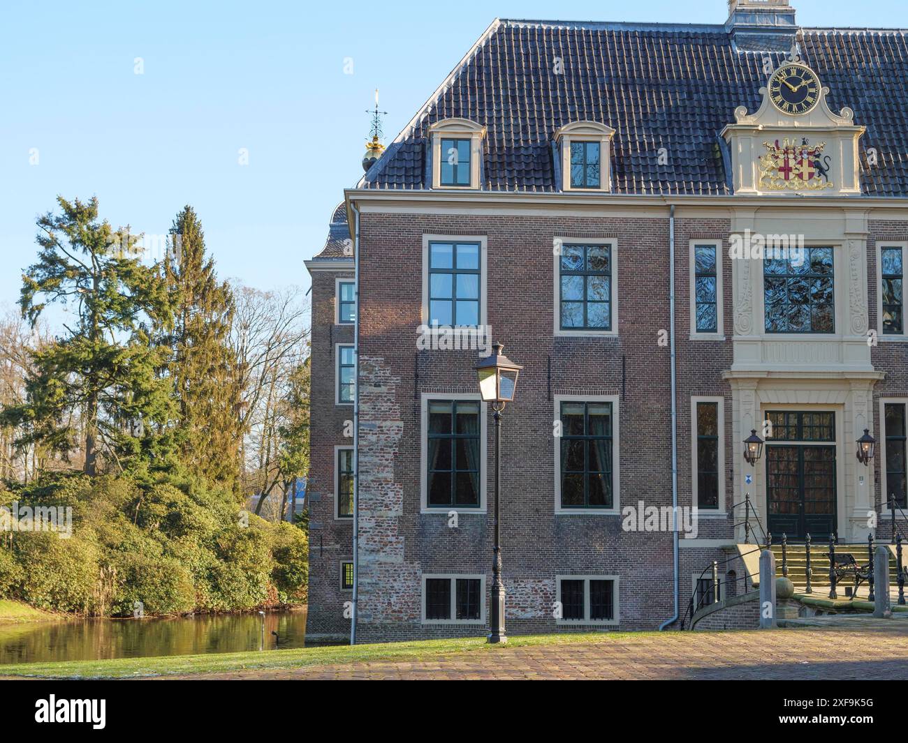 Part of a historic brick castle with windows, lantern and pond ...
