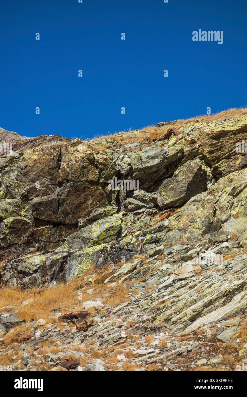 Rocky slope with stony terrain and dry grass under a clear sky, saas ...
