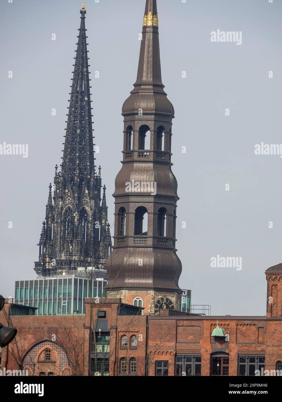 Picture shows two church towers and historic brick buildings under a ...